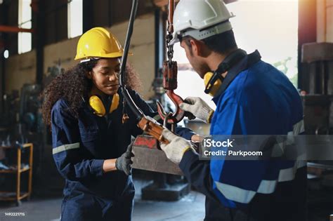 팀웍 기술자 엔지니어 또는 안전 안전모 스탠딩 및 유지 보수 작업을 하거나 중공업 제조 공장에서 오버헤드 크레인 원격 제어를 확인하는 보호 유니폼을 입은 작업자 16 17
