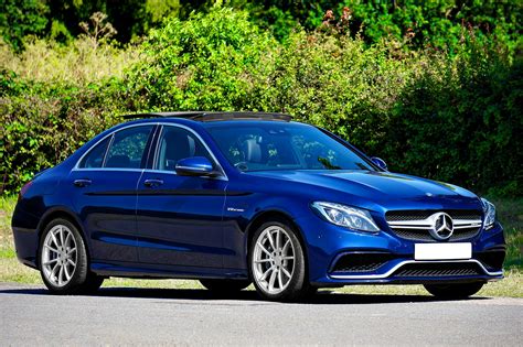 집 밖의 C 클래스 고급 승용차 고급 차량 고성능 고전적인 디자인 교통 기술 낮 네 개의 문 녹색 관목