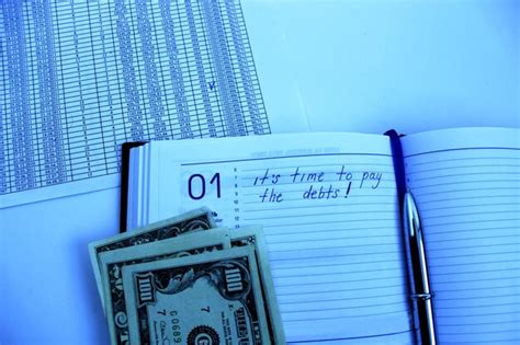 Premium Photo Writing Down In A Notebook About A Debt And American