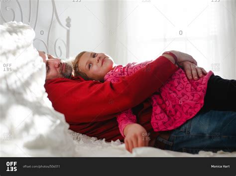 Dad And Babe Cuddling On A Bed Stock Photo OFFSET