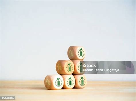 재생 에너지 환경 개발 개념 재사용 기호가 있는 녹색 배터리 전원 아이콘 및 나무 큐브 블록에 백분율 기호가 있는 위쪽 화살표 나무 테이블과 흰색 배경에 그래프 단계 재생