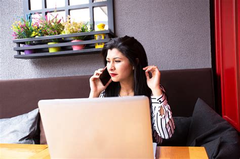 휴대 전화로 말하는 여자는 노트북으로 작업하고 있습니다 카페에서 노트북 야외에서 일하는 아름다운 갈색 머리 여자 경영자에 대한 스톡 사진 및 기타 이미지 Istock