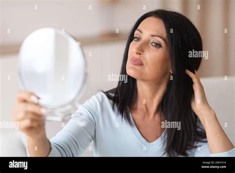 Adult Woman Checking Her Face In Mirror Stock Photo Alamy