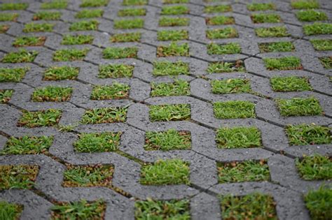 잔디가 있는 콘크리트 잔디 창살 회색 자연석으로 만든 사각형 타일의 배경 질감 도로의 콘크리트 가로 기하학적 포장 패턴 녹색