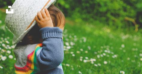 회색 재킷과 흰색 모자를 쓴 아이는 낮 동안 푸른 잔디밭에 서 있다 사진 Unsplash의 무료 모자 이미지