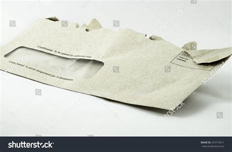 A Light Grey Window Envelope That Has Been Torn Open With The Words Confidential To Be Opened