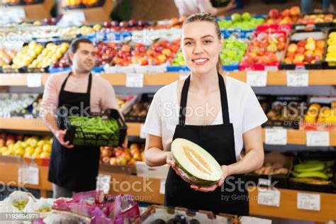 젊은 여성 판매자 와 반 의 멜론 과 남자 에 배경 데 상자 의 녹색 콩 에 슈퍼마켓 계절에 대한 스톡 사진 및 기타 이미지 계절 과일 긍정적인 감정 표현 Istock