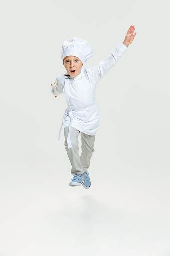 흰색 요리사 유니폼과 흰색 스튜디오 배경에 고립 실행 거대한 요리사의 모자를 한 작은 유치원 소년 6 7 살에 대한 스톡 사진 및 기타 이미지 Istock
