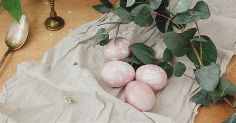 소박한 나무 테이블에 유칼립투스 가지가 있는 현대 부활절 달걀 세련된 파스텔 핑크 부활절 달걀과 사탕무에서 천연 염료로 칠해진 꽃 장식 행복한 부활절 인사말 카드 사진