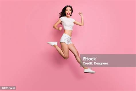 그녀의 전체 길이 몸 크기보기 그녀의 좋은 찾고 매력적인 꿈꾸는 즐거운 쾌활한 쾌활한 물결 모양의 머리 소녀 점프 재미 실행 을