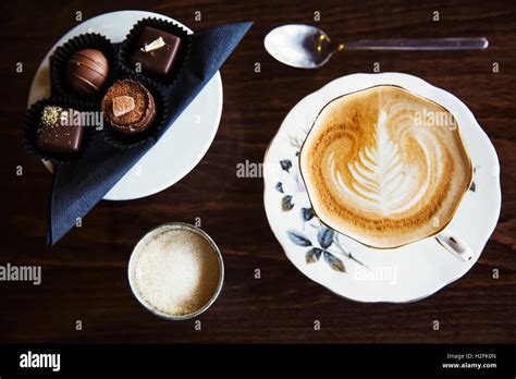 Assorted Hand Made Chocolates On A Plate A Cup Of Coffee With A