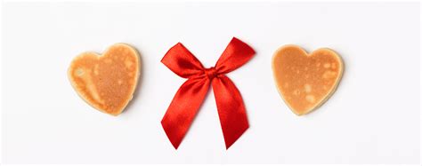 발렌타인 데이를위한 창조적 인 아침 식사 빨간 새틴 활 근처 흰색 배경에 하트 모양의 팬케이크 발렌타인 데이 배경입니다 맨 위 보기 플랫 레이 복사 공간 0명에 대한 스톡