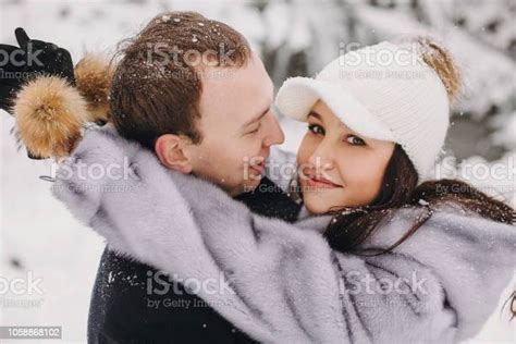 눈 덮인 겨울 산에서 포옹 사랑에 세련 된 커플 행복 한 로맨틱 남자와 여 자가 웃 고 눈에 폭포에서 포용의 초상화 휴일도 함께