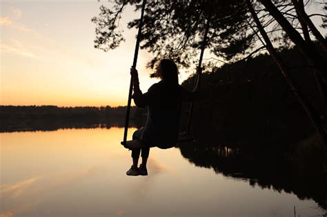 일몰에 호수 를 통해 스윙에 낭만적 인 젊은 여자의 실루엣 아름다운 자연속에서 그네에 앉아 있는 어린 소녀 여행자 호수의 전망 25 29세에 대한 스톡 사진 및 기타 이미지