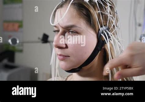 Young Woman Attending Clinic For Neurological Evaluation Using Eeg