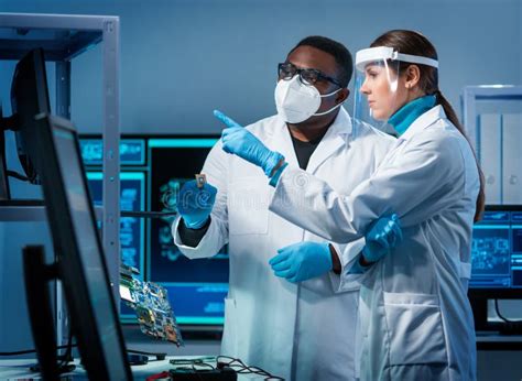 Group Of Microelectronic Engineers Discussing In A Modern Microprocessor Manufacture Lab