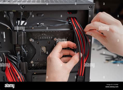 Computer Case With Motherboard And Power Supply Unit Being Held Open By A Hand With No Face