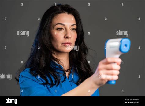 Beautiful Adult Woman Uses An Electronic Thermometer To Measure Temperature Stock Photo Alamy