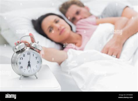 Woman Turning Off The Alarm Clock Stock Photo Alamy