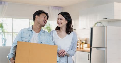 아시아의 젊은 행복한 새 결혼 부부가 함께 새 집으로 이사합니다 행복과 사랑으로 상자 소포와 여행 가방을 들고 매력적인 낭만적