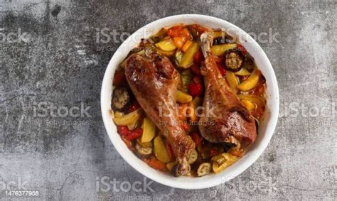 감자 가지 당근 및 피망과 같은 야채로 구운 칠면조 다리는 어두운 회색 배경의 흰색 베이킹 접시에 담겨 있습니다 상단보기 평평한 누워 가금류에 대한 스톡 사진 및 기타