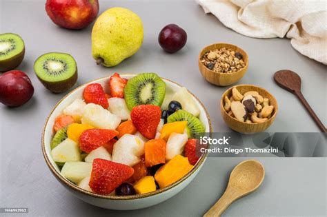그릇에 신선한 과일 샐러드입니다 여러 가지 빛깔의 열대 과일 파인애플 망고 포도 딸기 파파야 멜론 키위 밤과 그라 놀라가 추가됩니다 선택적 초점 0명에 대한 스톡 사진 및