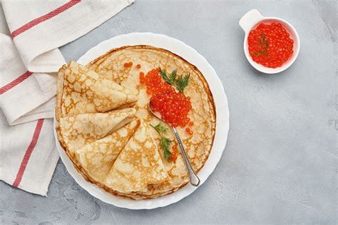 크레페 얇은 팬케이크 회색 접시에 빨간 캐비어가있는 러시아 팬케이크 대리석 배경 공간을 복사합니다 맨 위 보기입니다 0명에 대한