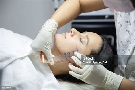 비 수술 성형 플라즈마 리프트 드로잉 및 통치자와 그녀의 얼굴에 섹션을 표시하는 여성 클라이언트를 준비하는 치료사 Smas 리프팅 Hufu 치료 고강도 중증 초음파 절차