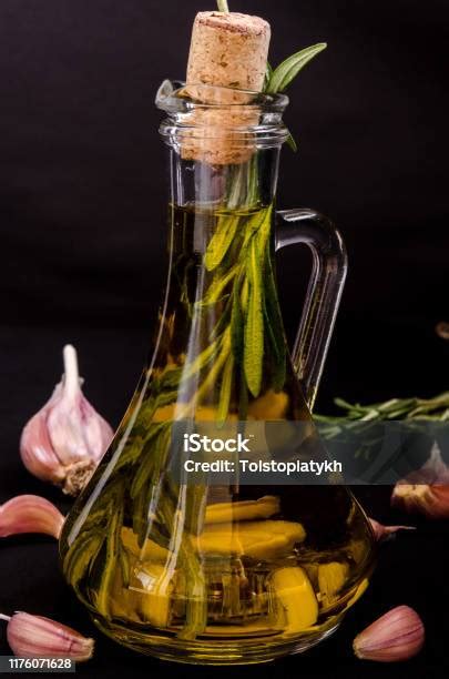 신선한 향기로운 올리브 오일과 신선한 로즈마리와 마늘 정향을 검은 색 배경에 유리 병에 담습니다 건강한 생활방식에 대한 스톡 사진 및 기타 이미지 Istock