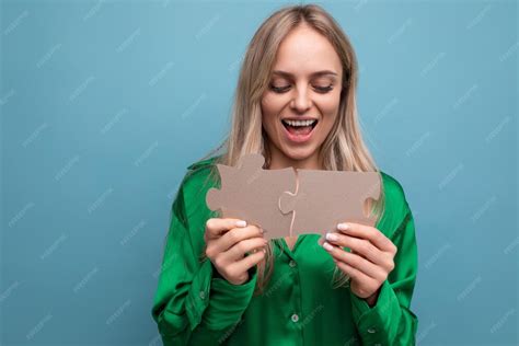 Premium Photo Joyful Young Blond Woman Solved The Puzzle And Put Together The Puzzle In Her