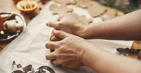 크리스마스 진저 브레드 쿠키 만들기 롤링 핀 금속 절단기 아니스 생강 계피 솔방울 소박한 테이블에 전나무 가지를 배경으로 생 반죽을 반죽하는 손 사진
