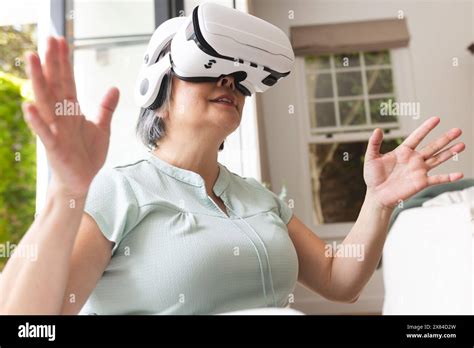 Senior Asian Woman At Home Uses Vr Headset To Explore A Digital World Stock Photo Alamy