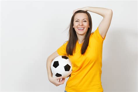 아름 다운 유럽 젊은 쾌활 한 행복 한 여자 축구 팬 또는 선수 축구 공을 들고 노란색 유니폼에 흰색 배경에 고립 스포츠 축구 건강 건강 한 라이프 스타일 컨셉 놀이