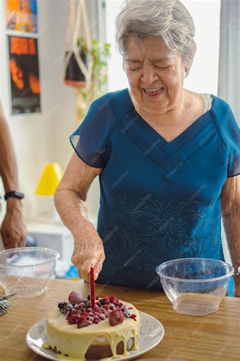 Premium Photo Elderly Woman Enjoying Cutting Her Own Birthday Cake