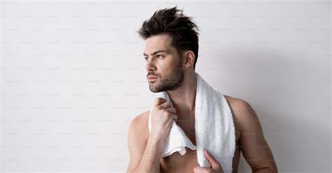 헝클어진 머리를 한 뻣뻣한 남자가 서서 목에 흰 수건을 들고 있습니다 그는 진지하게 옆을 바라보고 있습니다 왼쪽의 복사 공간 사진 Unsplash의 복사 공간 이미지