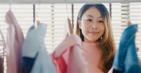 아름다운 매력적인 젊은 아시아 아가씨는 집이나 상점의 옷장에서 패션 의상 옷을 선택합니다 소녀는 캐주얼 셔츠를 입을 것을 생각합니다 홈 옷장 또는 옷가게 탈의실 사진