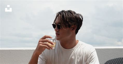 흰색 크루넥 티셔츠와 검은색 바지를 입은 남자가 검은색 강철 안락의자에 앉아 있다 사진 Unsplash의 무료 브리즈번 Qld 이미지