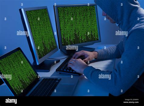 high angle view of hacker in hooded jacket using computer at table