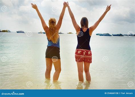 Feeling Free Rearview Shot Of Two Young Girlfriends Enjoying A Day At