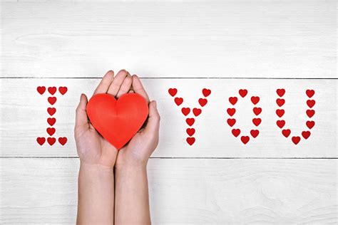 발렌타인 데이 배경 빨간 종이 하트와 여성의 손에 한 마음으로 만든 당신을 사랑합니다 서명 복사 공간 인사말 카드 모형 사랑의 상징 사랑 개념 상단 보기 플랫 레이 2월에