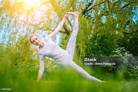 공원에서 요가 아사나를하고 젊은 여자 요가 자세로 운동을 스트레칭 하는 소녀 행복하고 건강한 여자는 연꽃 위치에 앉아 요가를 연습 야외에서 일몰에 명상과 스포츠 강사에 대한