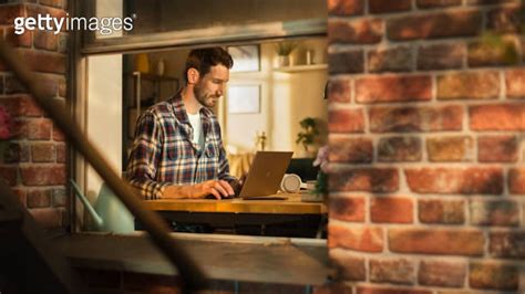 Male Software Engineer Coding On Laptop Computer Working In Modern Apartment Professional It