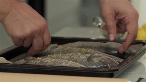 Male Hands Prepare Several Fish For Baking On A Baking Sheet Add Oil