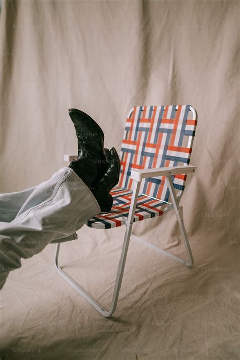 Foto Una persona acostada en una silla con los pies en alto – Zapatos ...