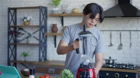 Young Asian Man Assembling Blender In Kitchen At Home In The Morning