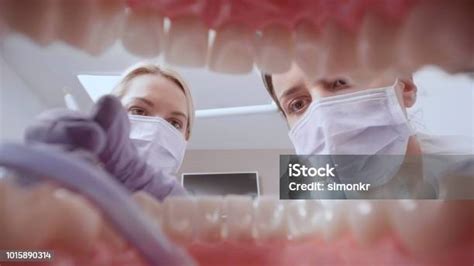 치과 의사는 치아에 작업을 시작 하기 전에 환자의 입 속으로 흡입 호스를 배치 하는 조 수술복에 대한 스톡 사진 및 기타 이미지 수술복 3 명 30 34세 Istock