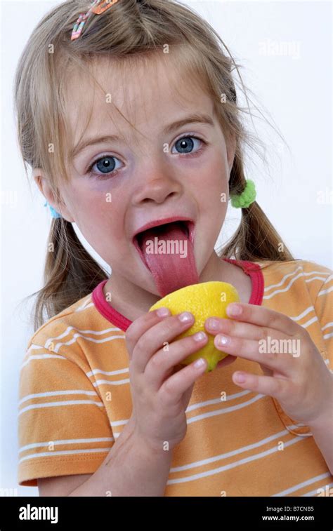 Small Girl Licking At A Lemon Stock Photo Alamy