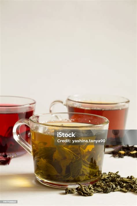 흰색에 마른 잎과 녹온 차 흰색 배경에 검은 색 빨간색 및 녹차가있는 3 개의 유리 컵 레드 핫 히비스커스 차 홍차 건강한 라이프 스타일 뜨거운 음료 수직 방향 0명에 대한