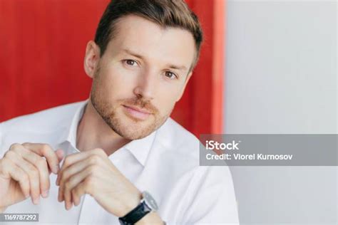 흰색 셔츠를 입은 사려 깊은 자신감 있는 남성 기업가의 이미지는 회의 중에 비즈니스 파트너를 주의 깊게 듣고 흰색과 빨간색