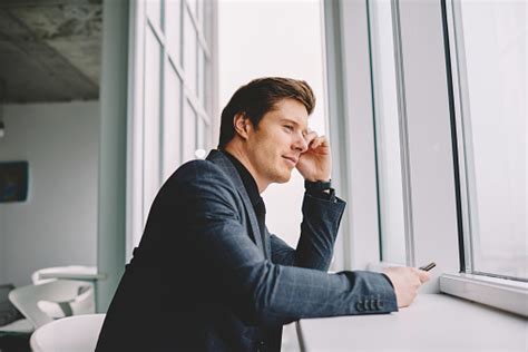 미래의 계획에 대해 생각 로프트 인테리어 사무실에서 창을보고 꿈꾸는 번영 사업가 휴식에 대한 아이디어에 집중 작업 휴식에 여가를
